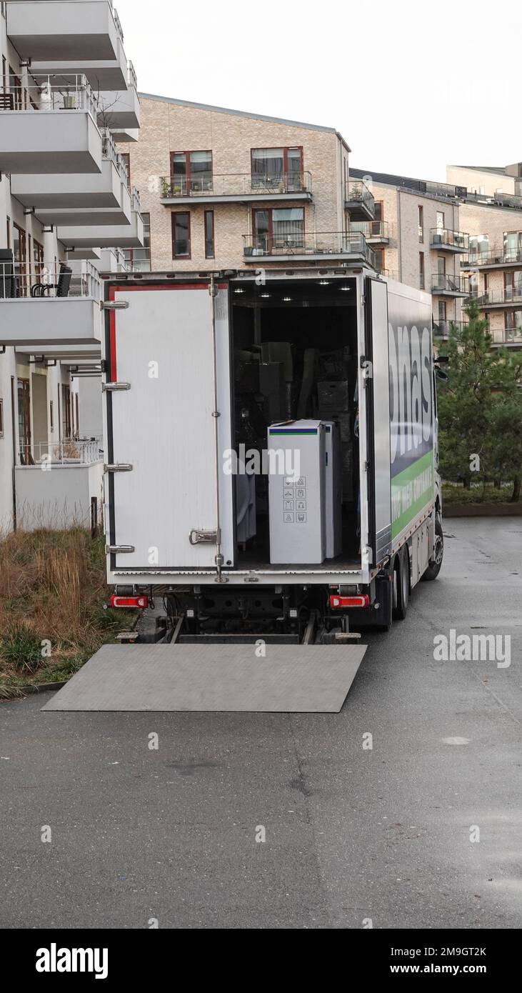 Delivery truck with tailgate open in front of an office building ...