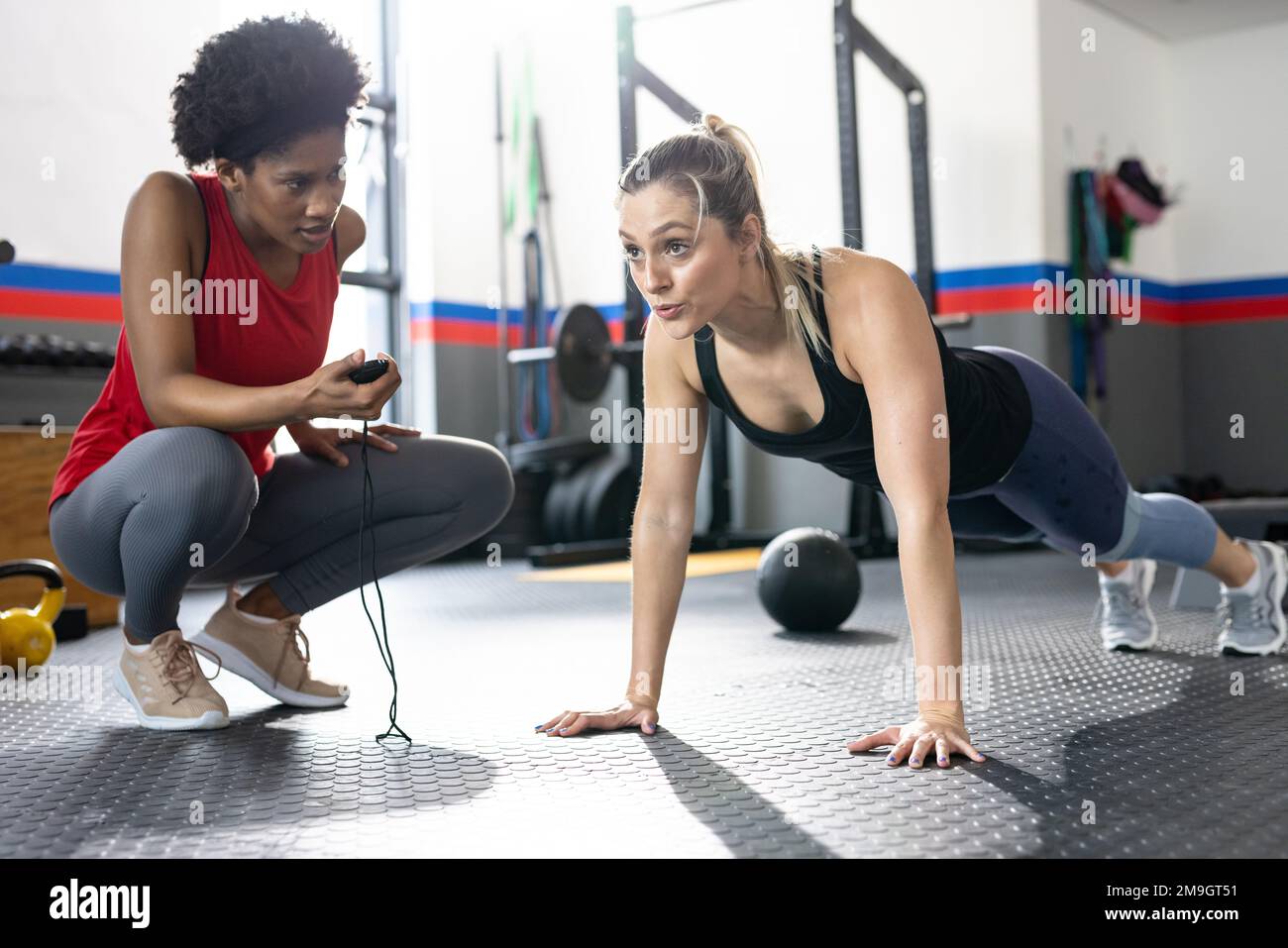 Caucasian fit woman exercising and doing push ups with african american ...