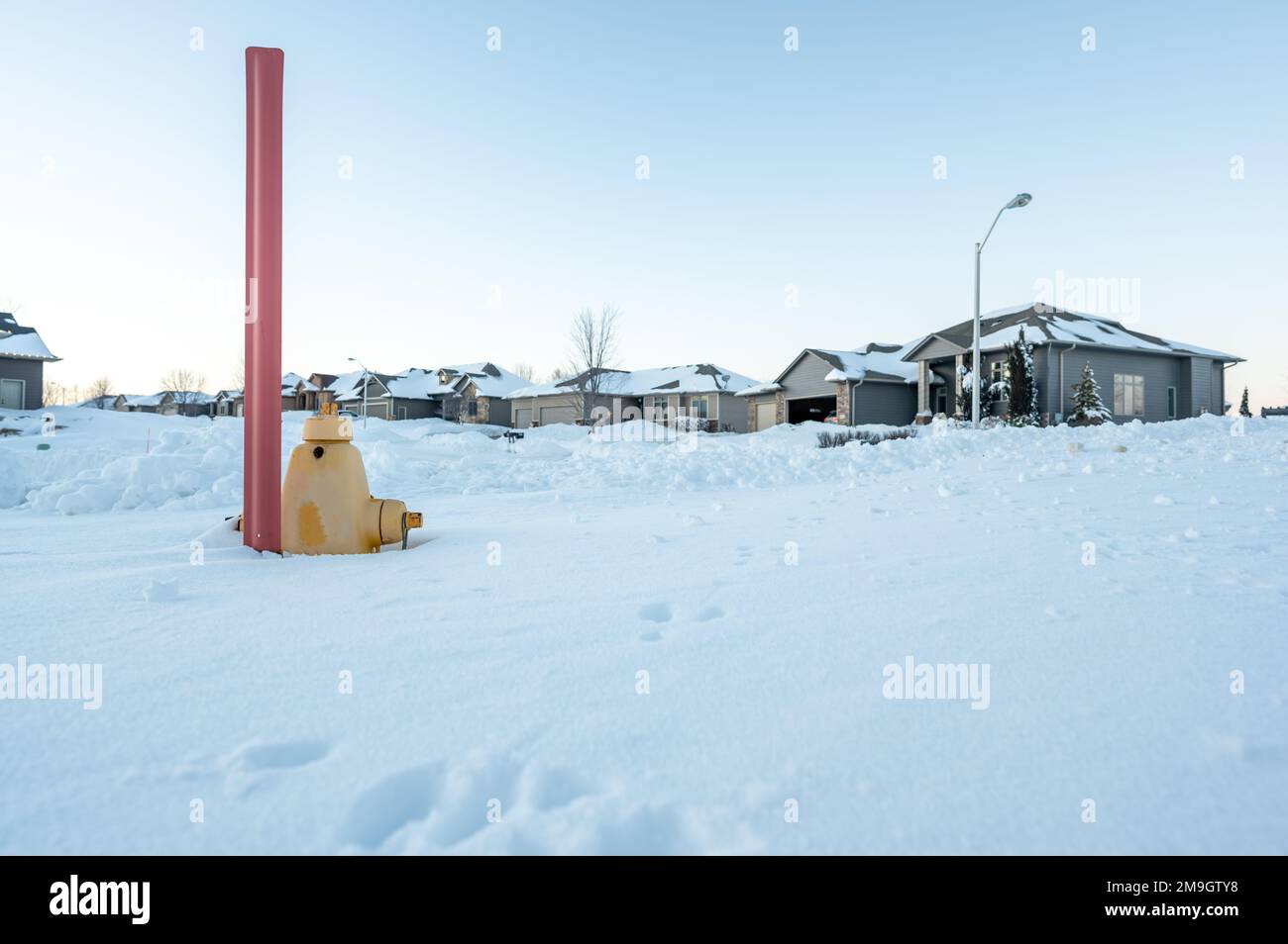 Fire hydrant with a locator protruding from a snow back along a ...