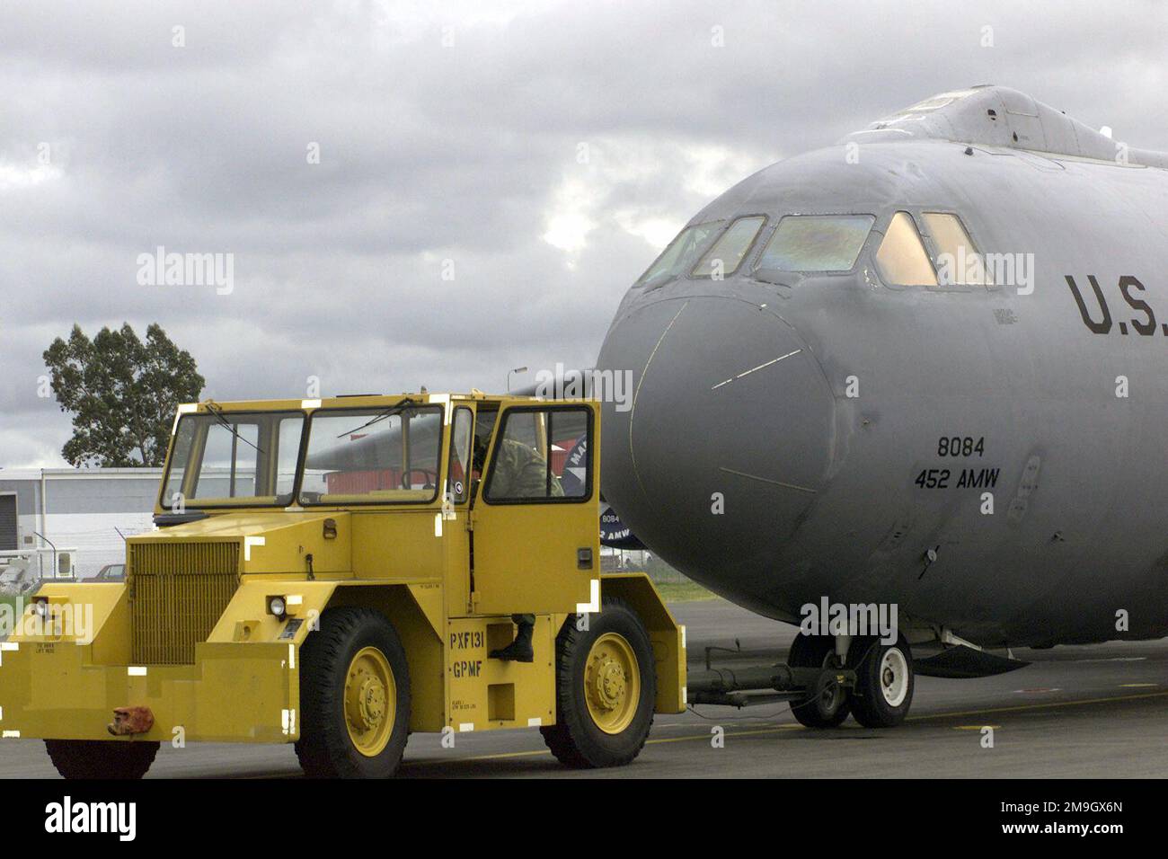 A cargo tug tows a broken C-141C Starlifter on the flightline in ...