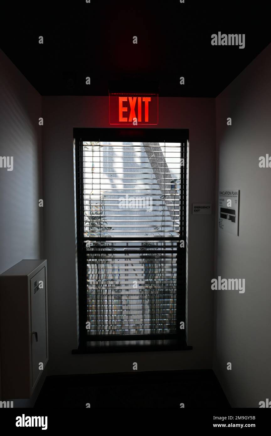 A vertical shot of an interior of a hotel corridor with an exit escape ...