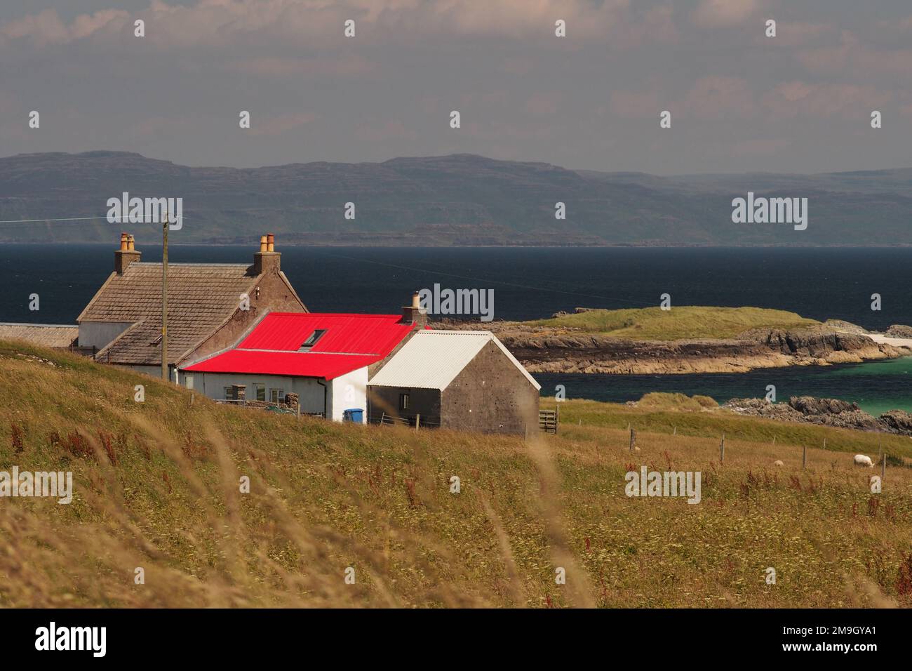 Looking past a red roofed house over to White Strand of Monk's beach ...