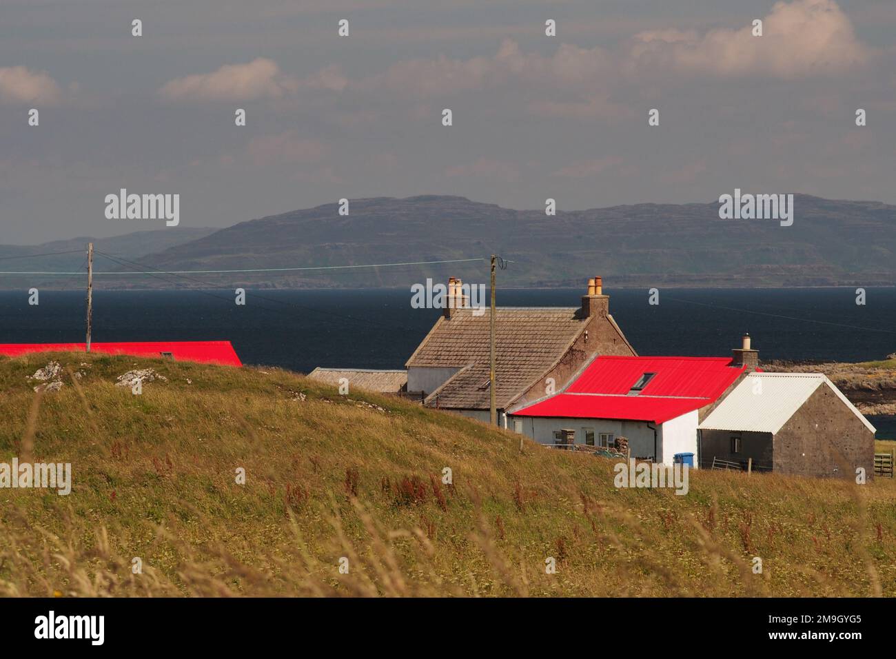 Looking past a red roofed house over to White Strand of Monk's beach ...