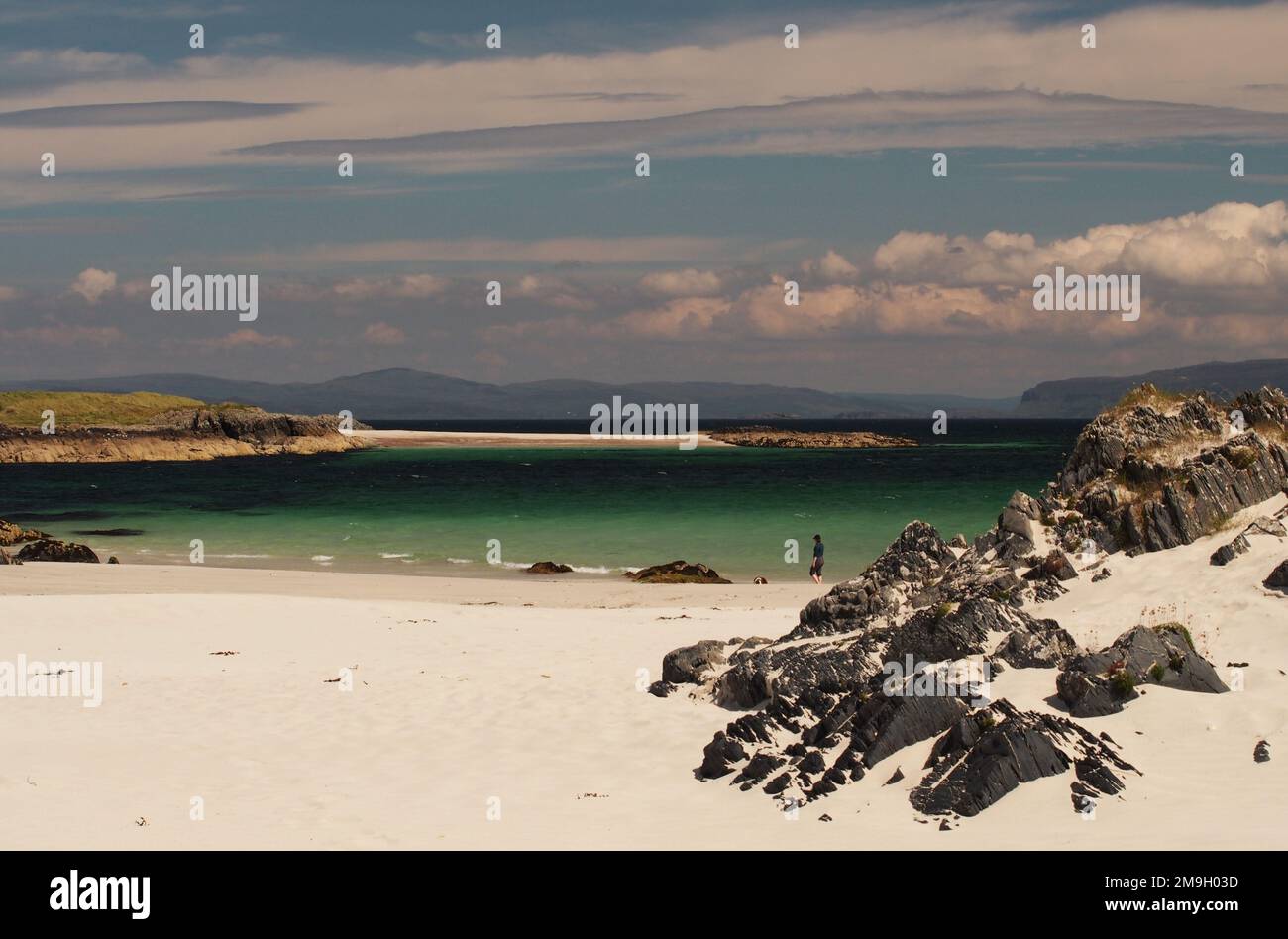 A man walking on White Strand of the Monk's beach, Iona, Scotland UK ...