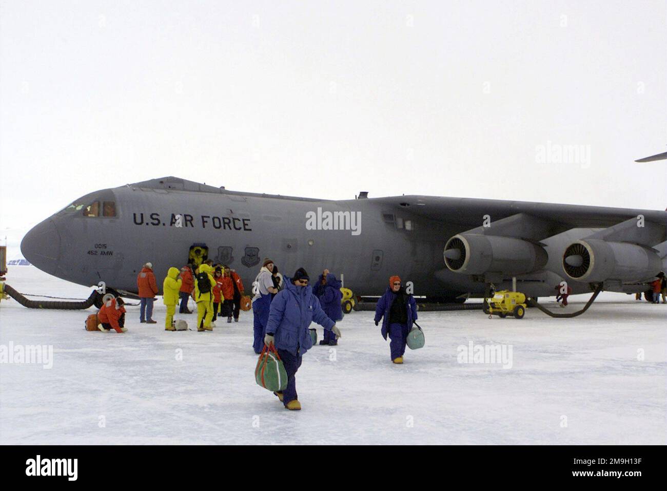 Scientist, passengers and support personnel deplane a Lockheed C-141C ...