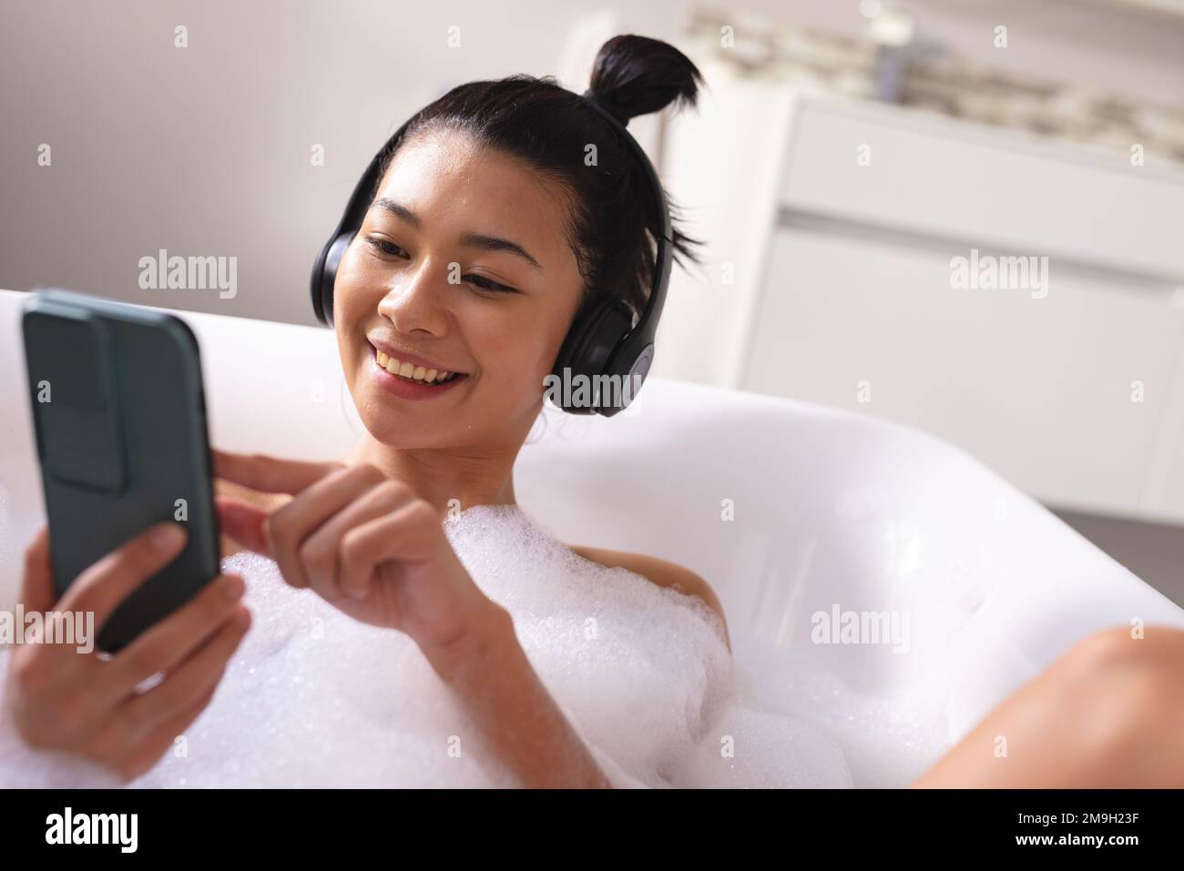 Image Of Biracial Woman Relaxing With Headphones And Smartphone In