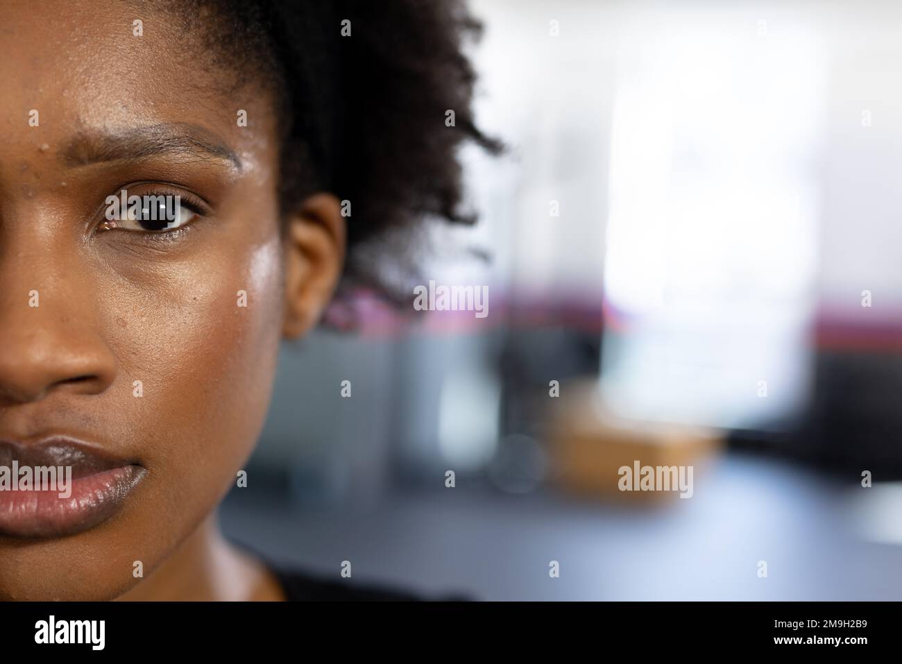 Close up, half face portrait of african american fit woman alone at gym ...