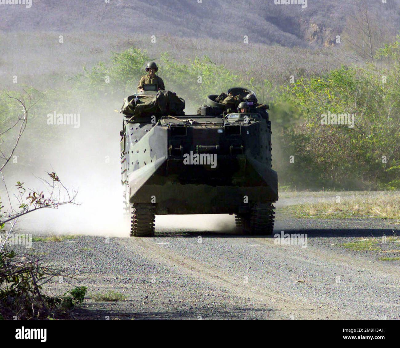 An USMC AAV7A1 Amphibious Assault Vehicle moves along a dirt road at ...