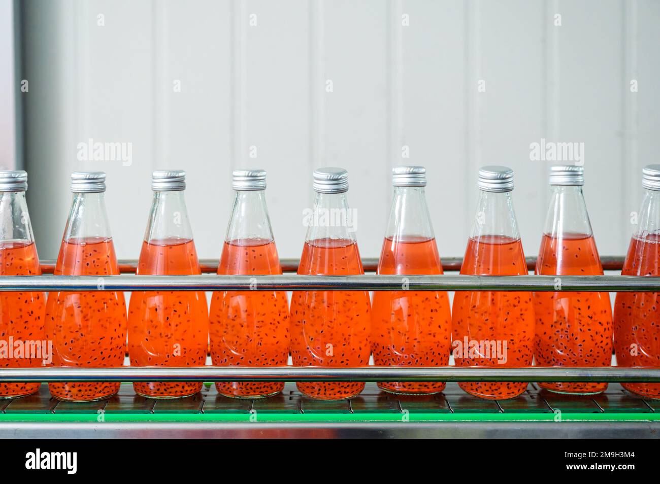 Automated production line of bottled juice beverage moving on conveyor ...