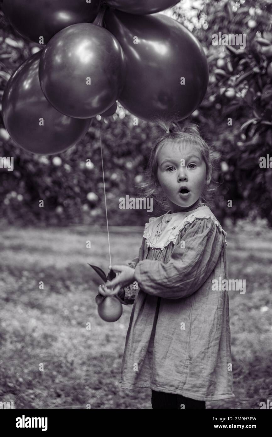 Beautiful Girl in the Orange Garden and ripe oranges on the branches of ...