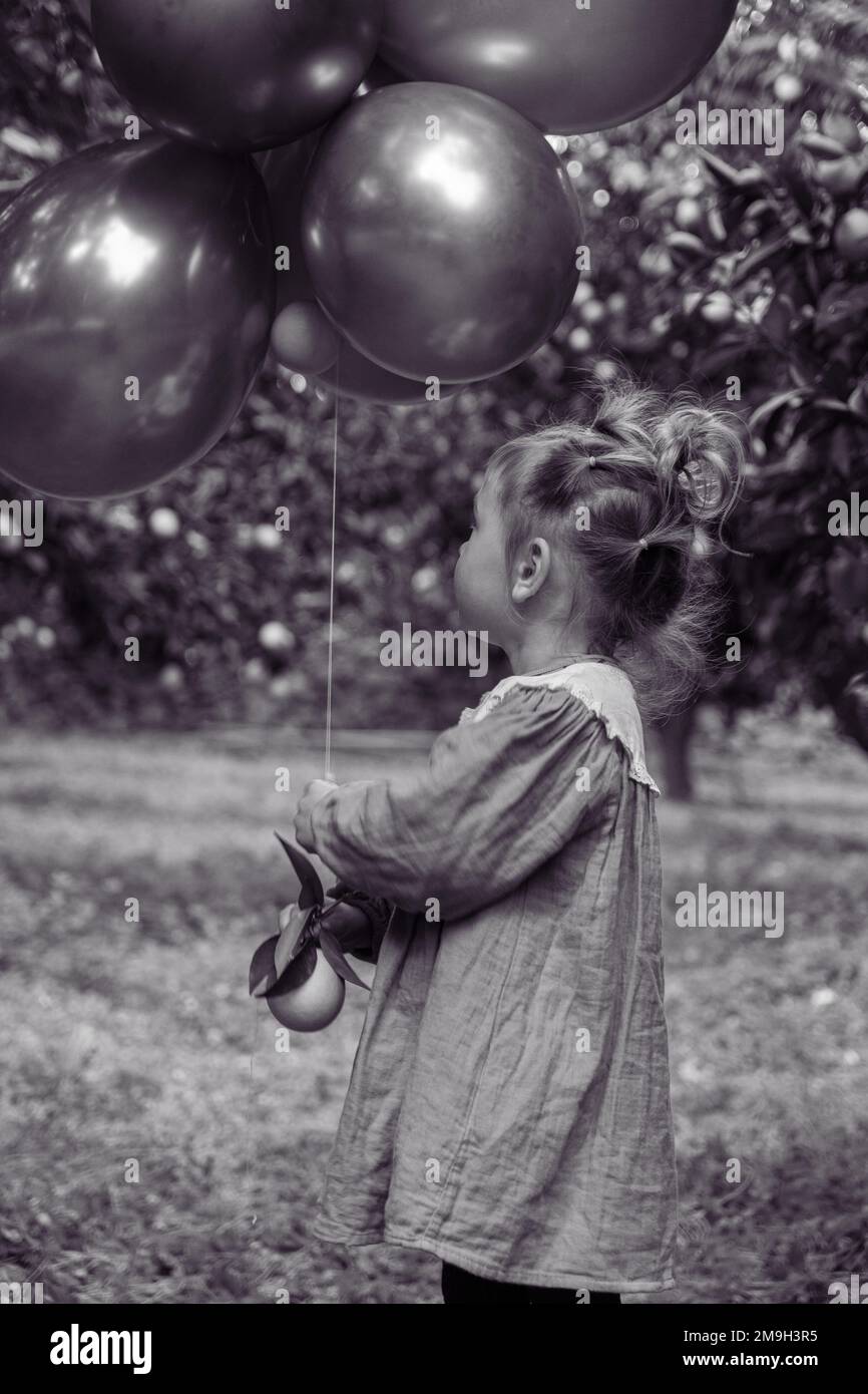Beautiful Girl in the Orange Garden and ripe oranges on the branches of ...