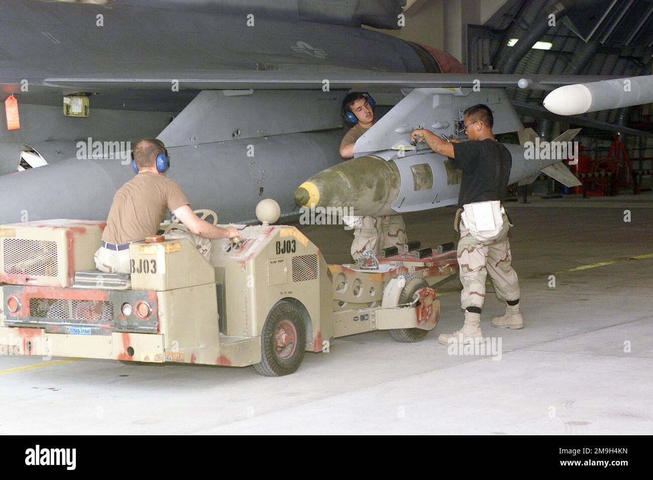 Members from the 389th Fighter Squadron (FS), finish attaching a weapon ...