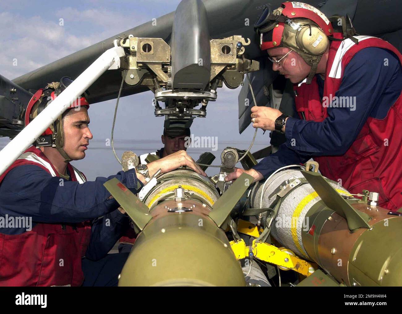 US Marine Corps personel attach an AIM 9 Sidewinder missle to an AV-8B ...