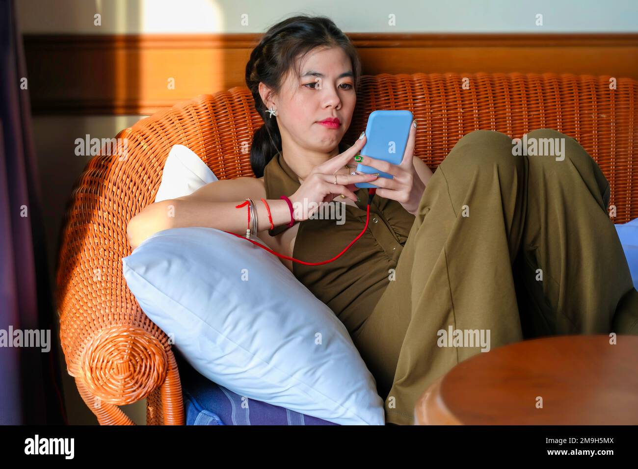 Bored young woman holding a mobile phone Stock Photo - Alamy