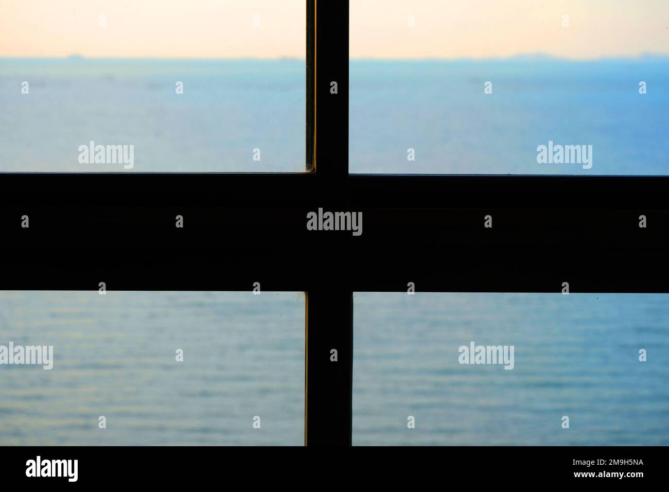 View of the ocean from inside a window with sunset Stock Photo - Alamy