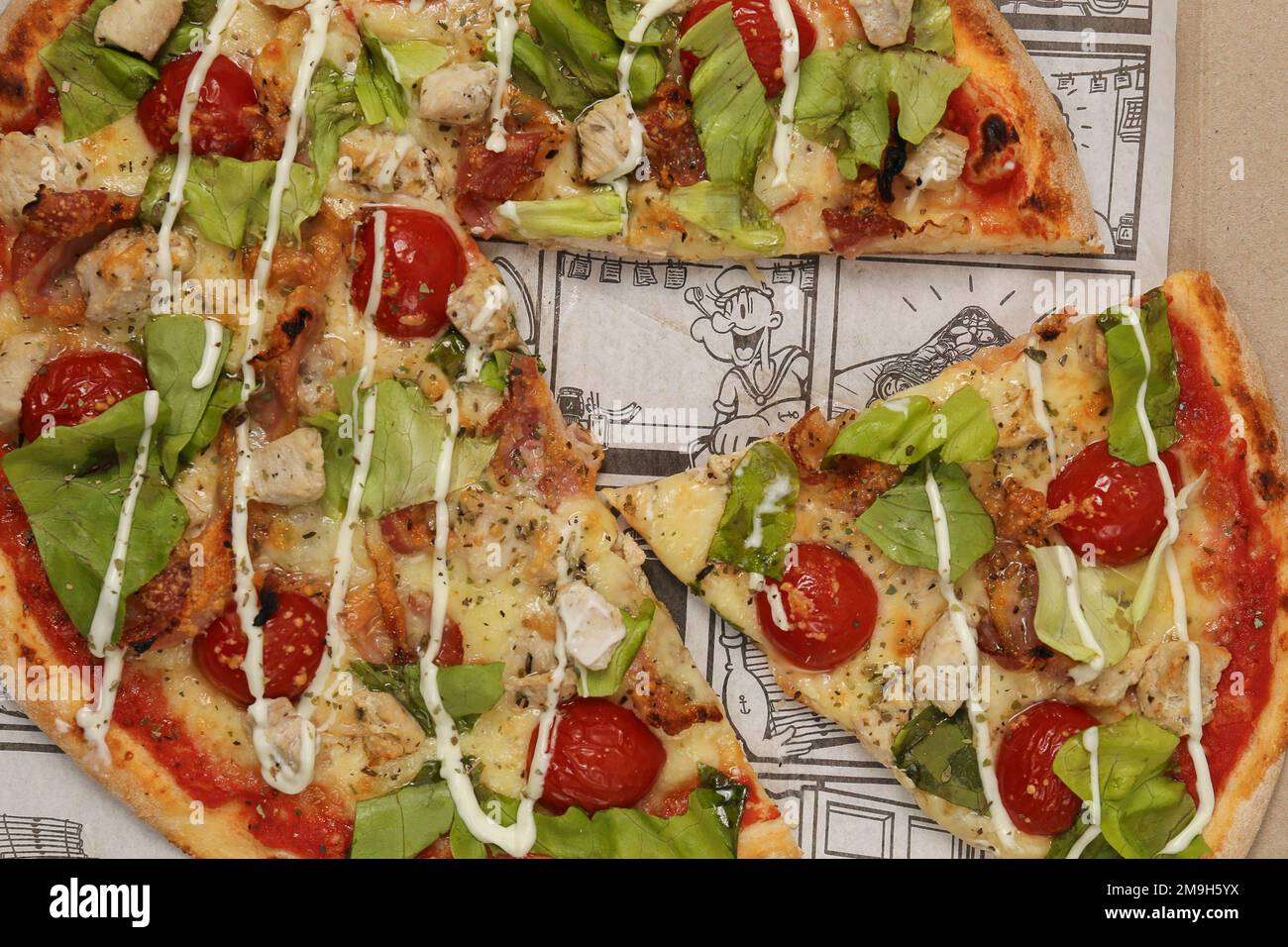 A high angle shot of a gourmet pizza with various toppings on a messy ...