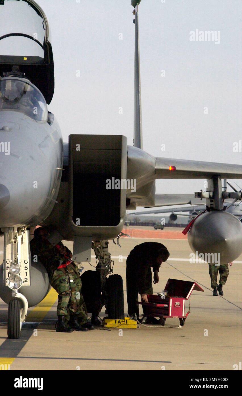 Ground crew members perform last minute maintenance on a United States ...