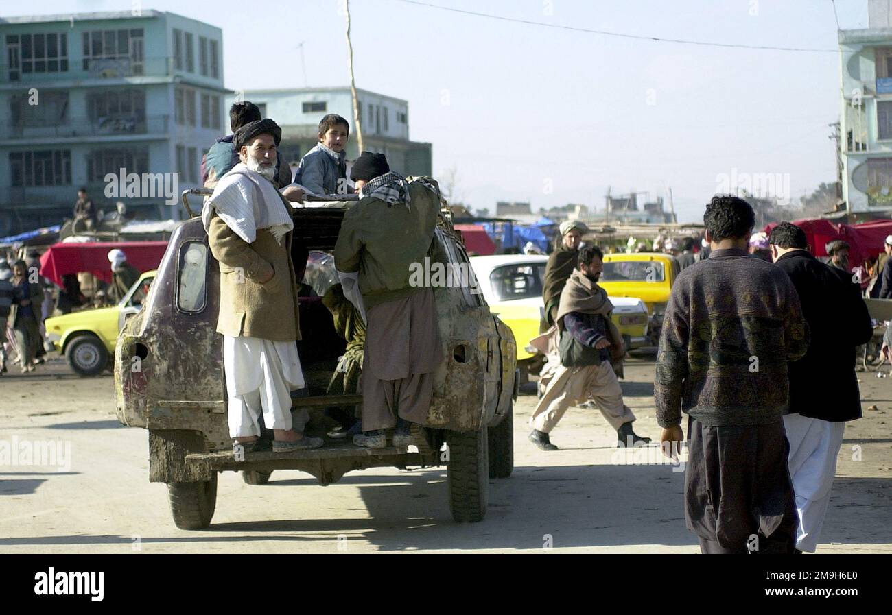 Local Afghanis ride a taxi at the Mazar-e Sharif airfield during ...