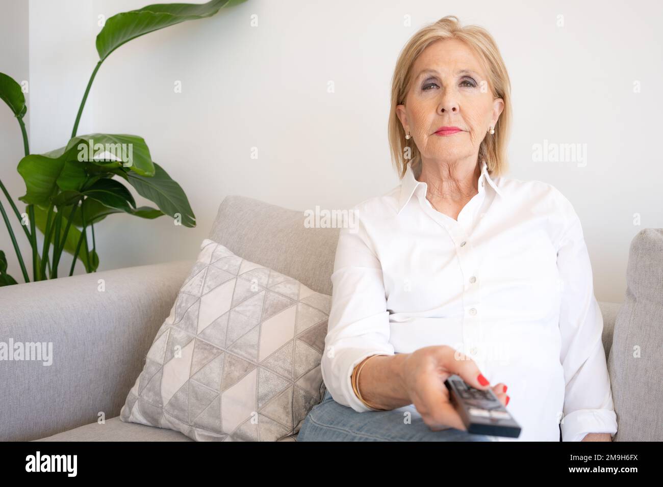 Old lady watching tv on sofa hi-res stock photography and images - Alamy