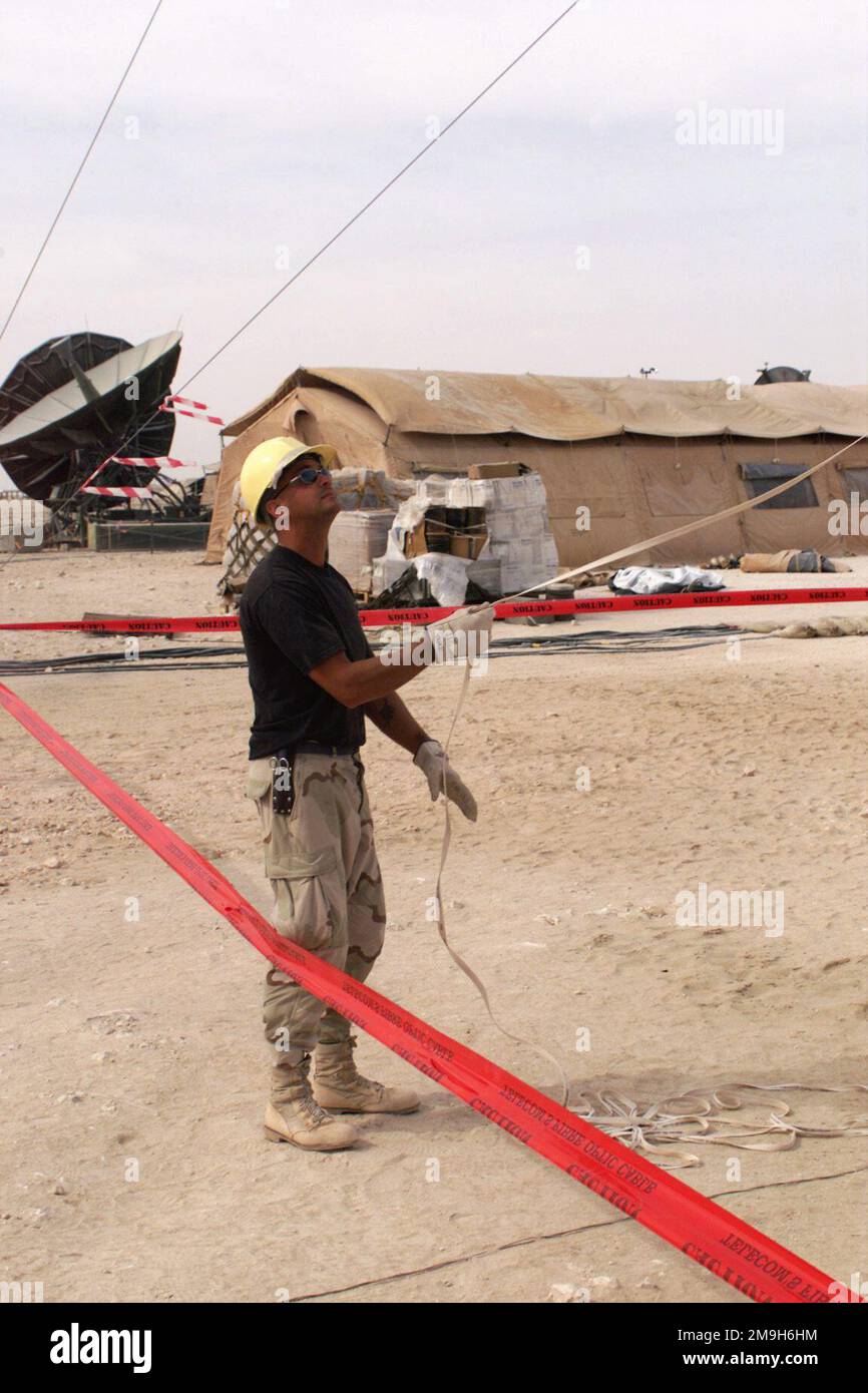 Technical Sergeant (TSGT) Dave Trychon secures a tether line to a work ...
