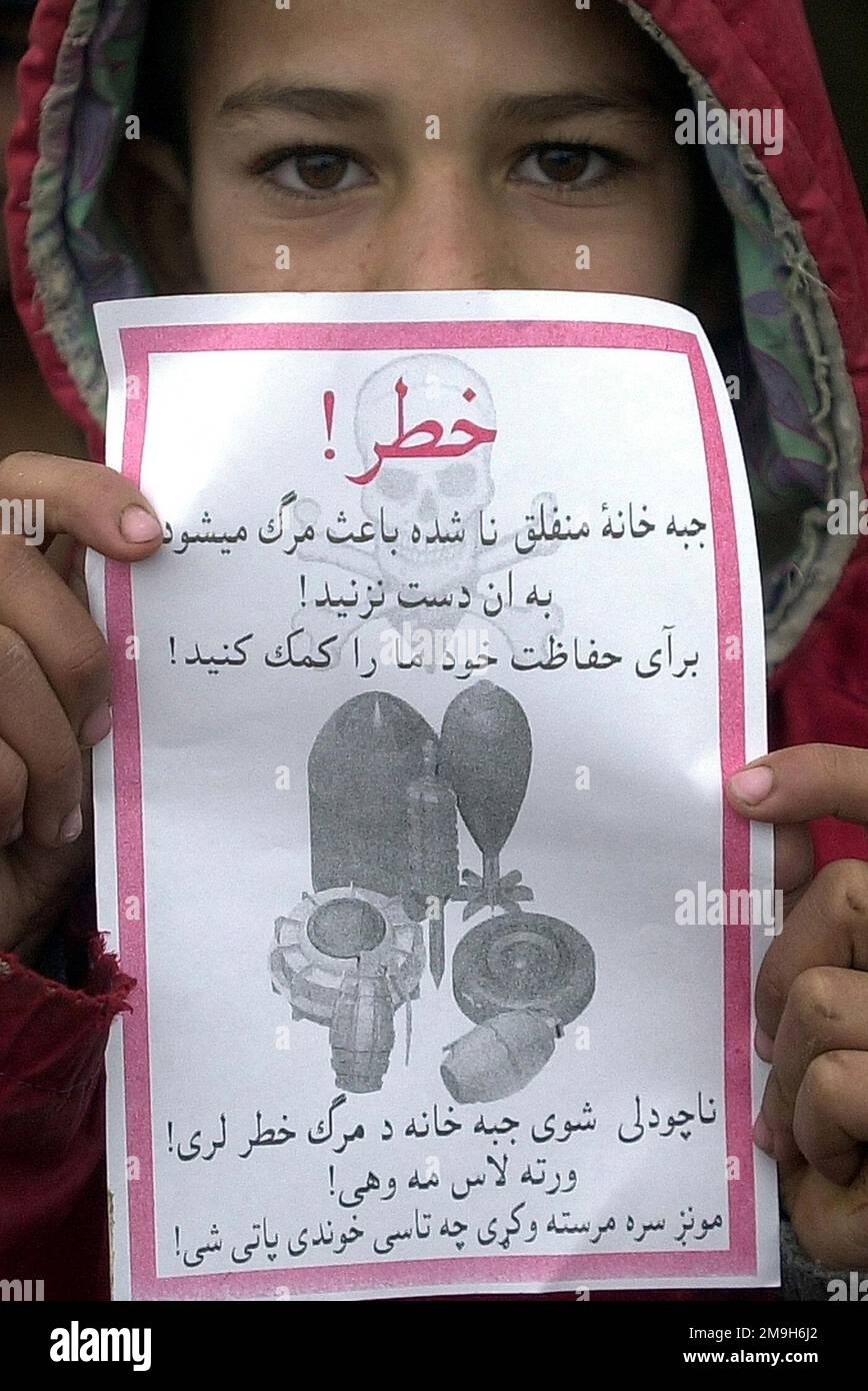 A local Afghani child in Mazar-e Sharif, Afghanistan holds up a leaflet ...