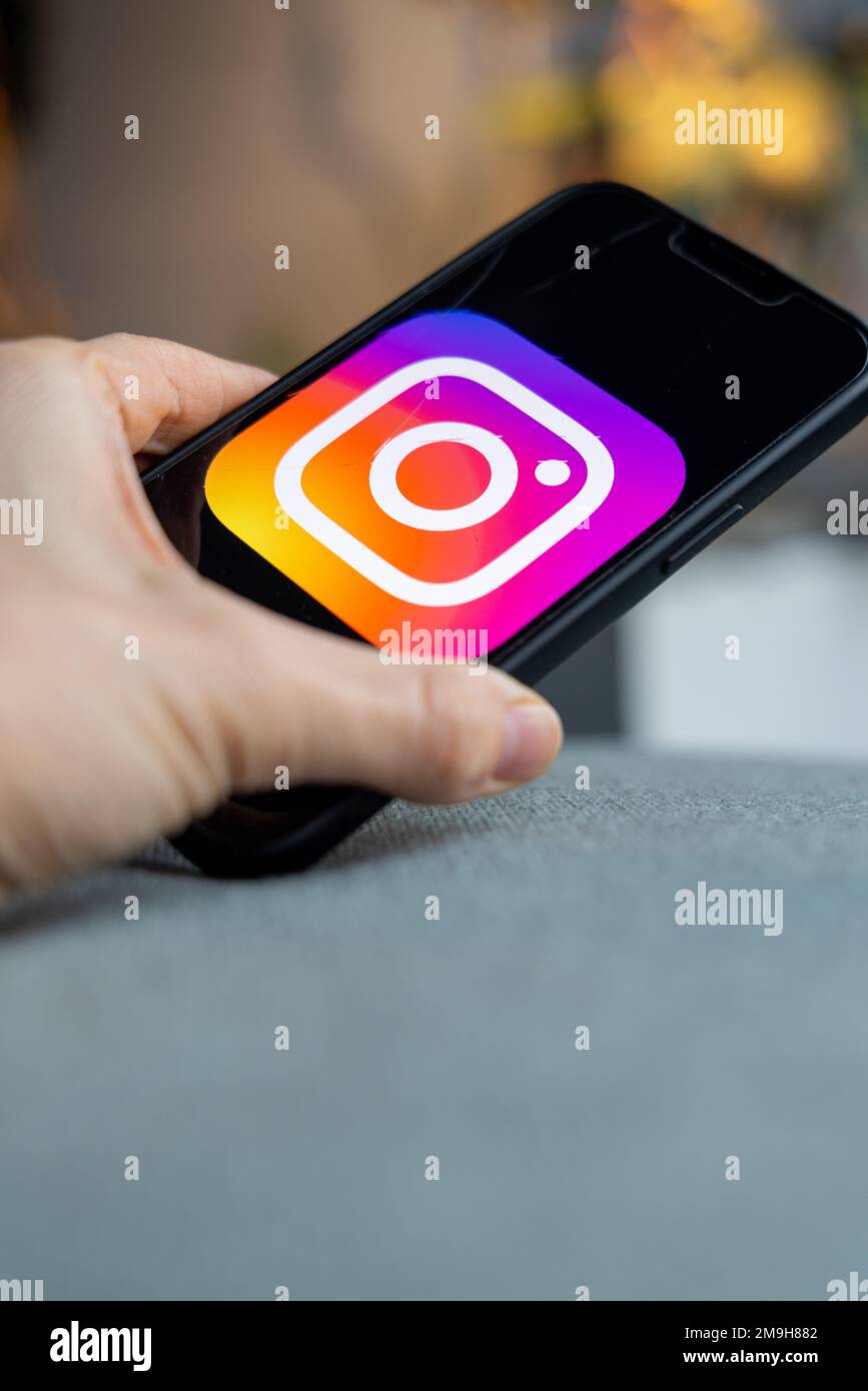 Hand holding a smartphone with an Instagram icon on screen. IPhone with ...