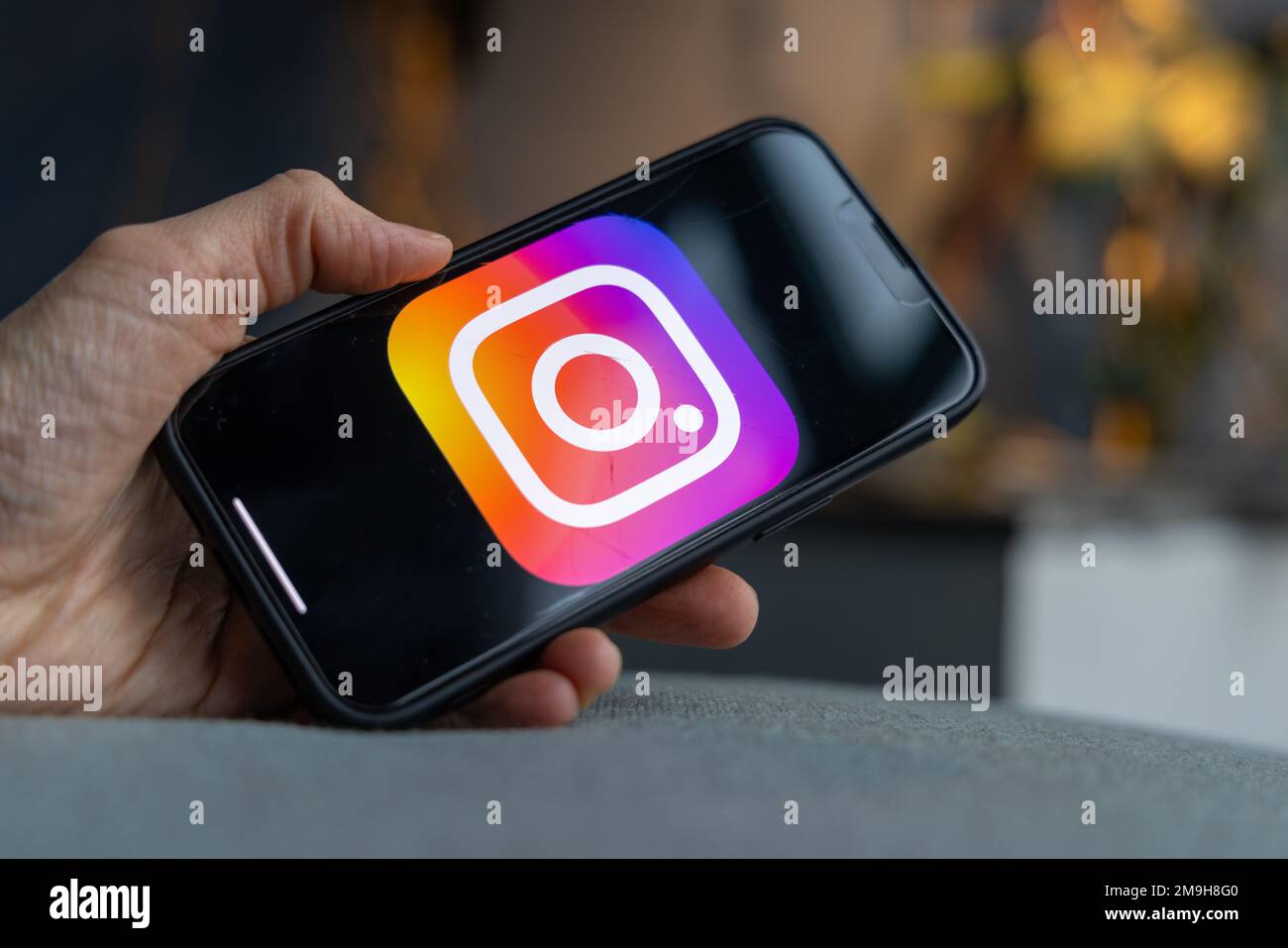Hand holding a smartphone with an Instagram icon on screen. IPhone with ...