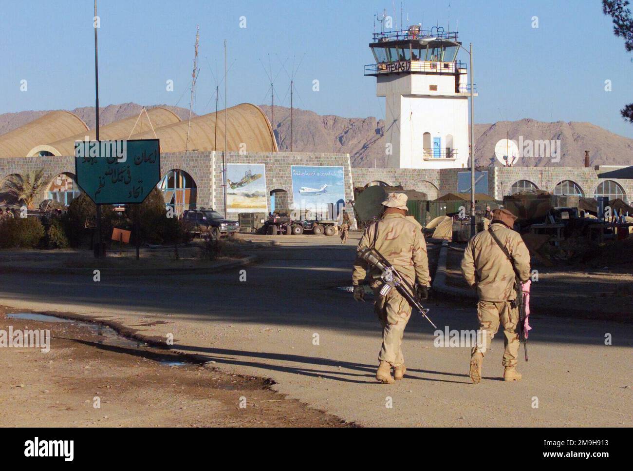 A pair of Marines carrying their M-16s walk through the main ...