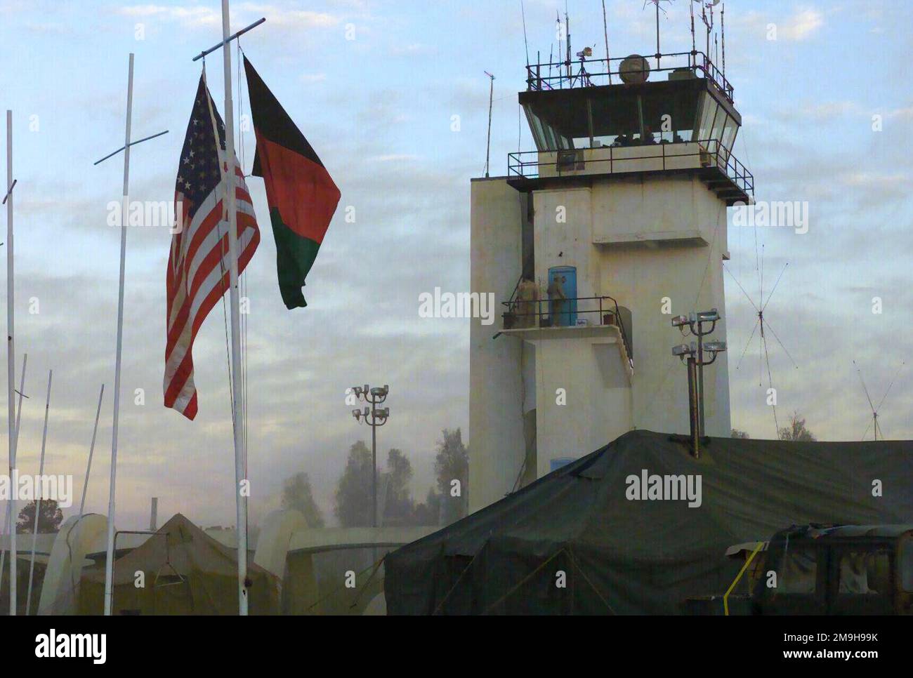The American and Afghan flags fly in front of the air control tower at ...