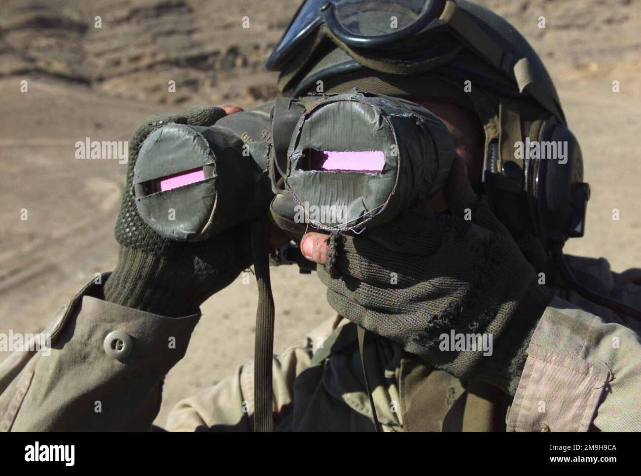 Marine Corporal David Easter peers through binoculars while ...