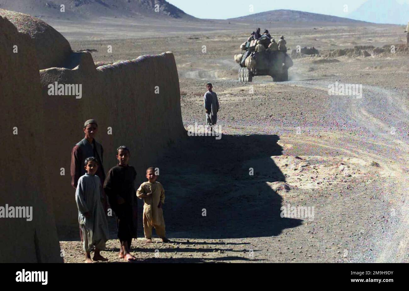 As the first LAV-25 (Light Armored Vehicle) rolls off into the distance, an Afghan family ...