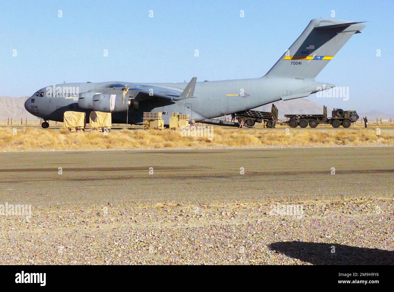 A US Air Force C-17 Globemaster III offloads a LVS Dragon Wagon (MK48 ...