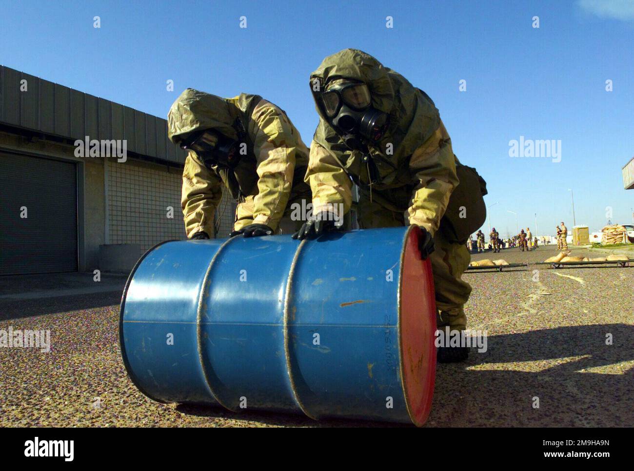 Marines with Combined Joint Task Force (CJTF) roll a barrel filled with ...