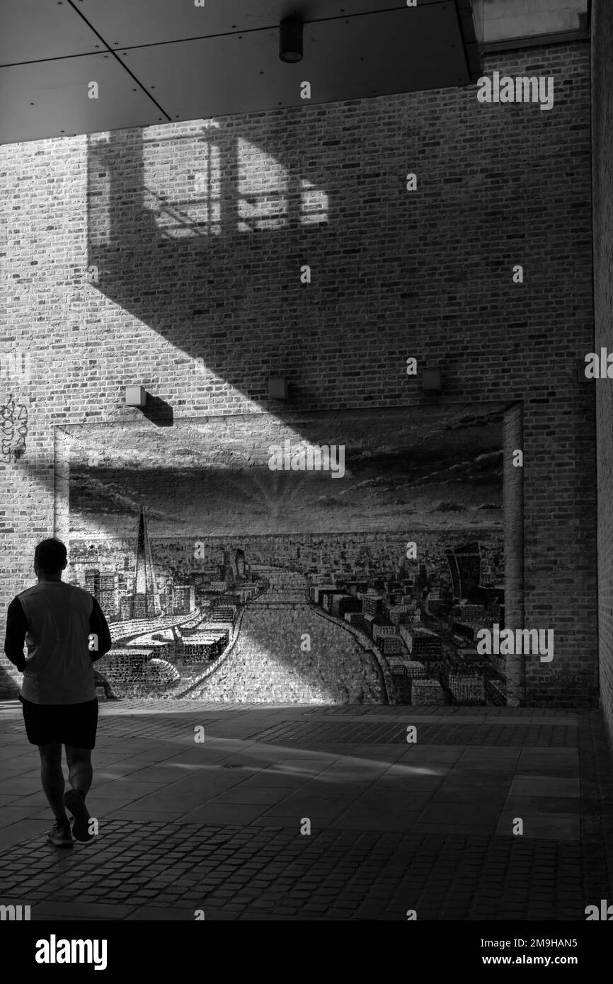 Man walking past Bankside Yards, London UK in September - black and ...