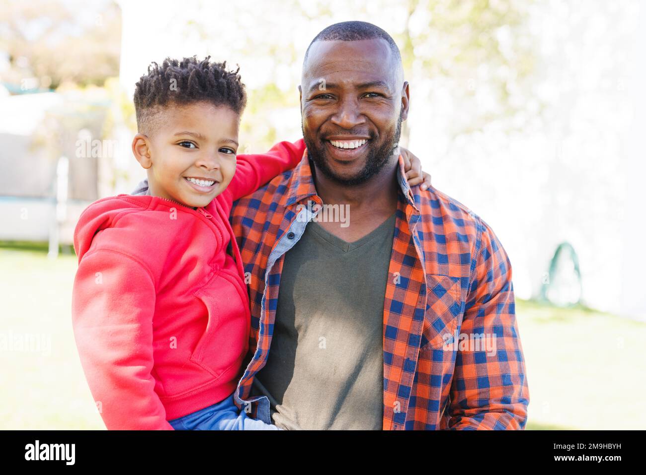 Portrait of happy african american father and son embracing and smiling ...