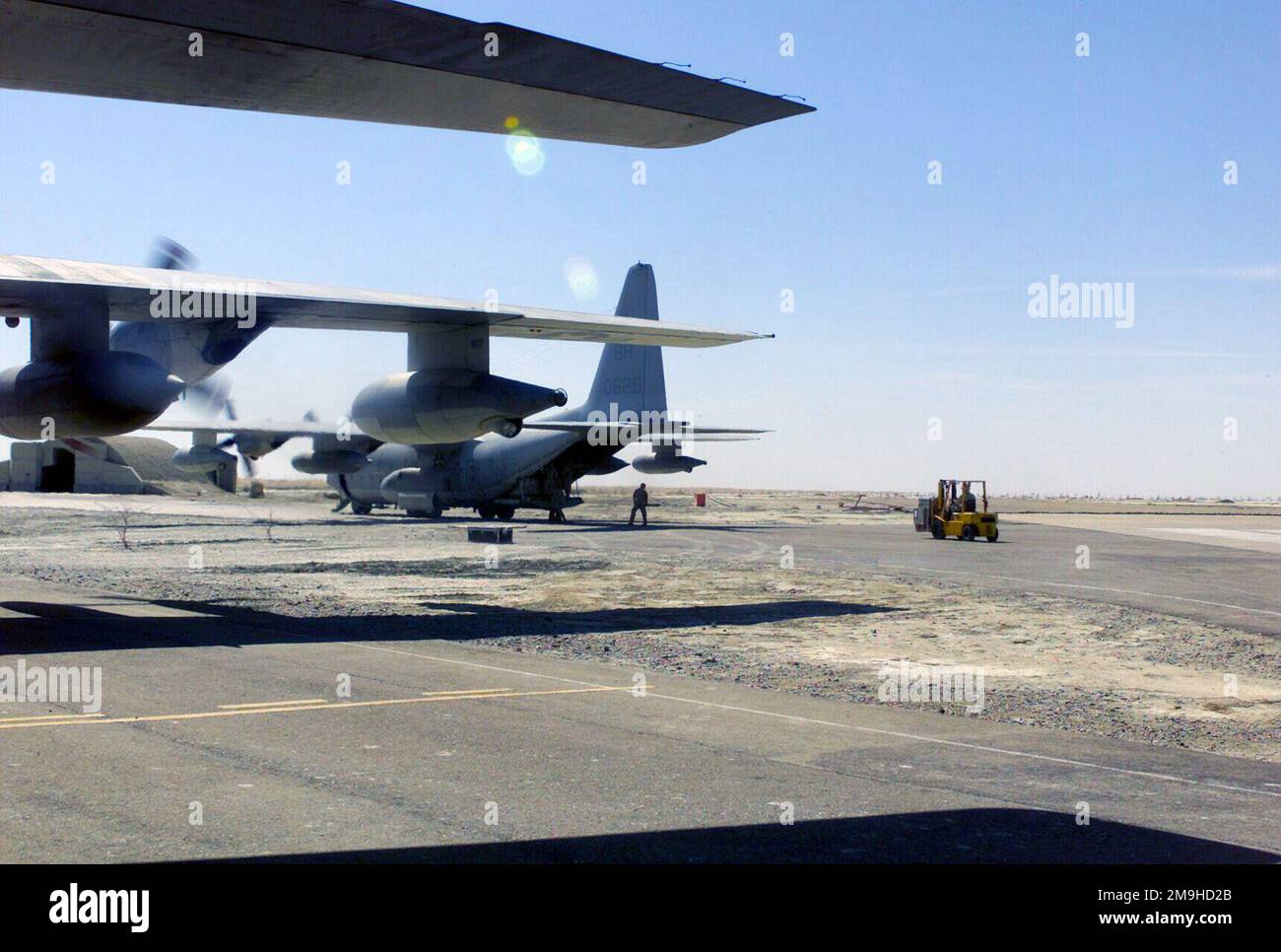 At a forward operating base, a small two-ton forklift works to load ...