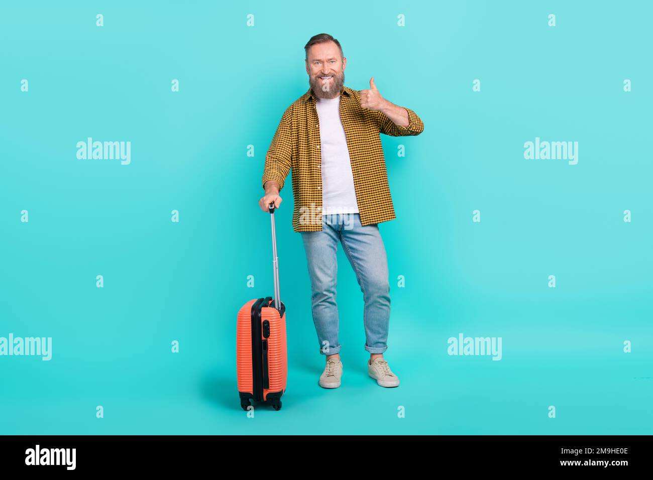 Photo of positive attractive man stylish clothes hold baggage thumb up ...