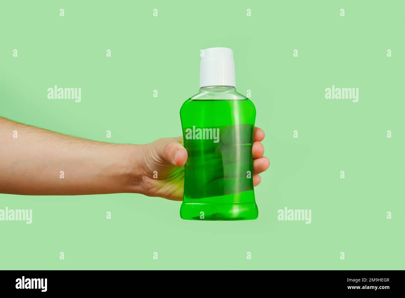 Mockup of unbranded bottle with green liquid for branding and label and ...