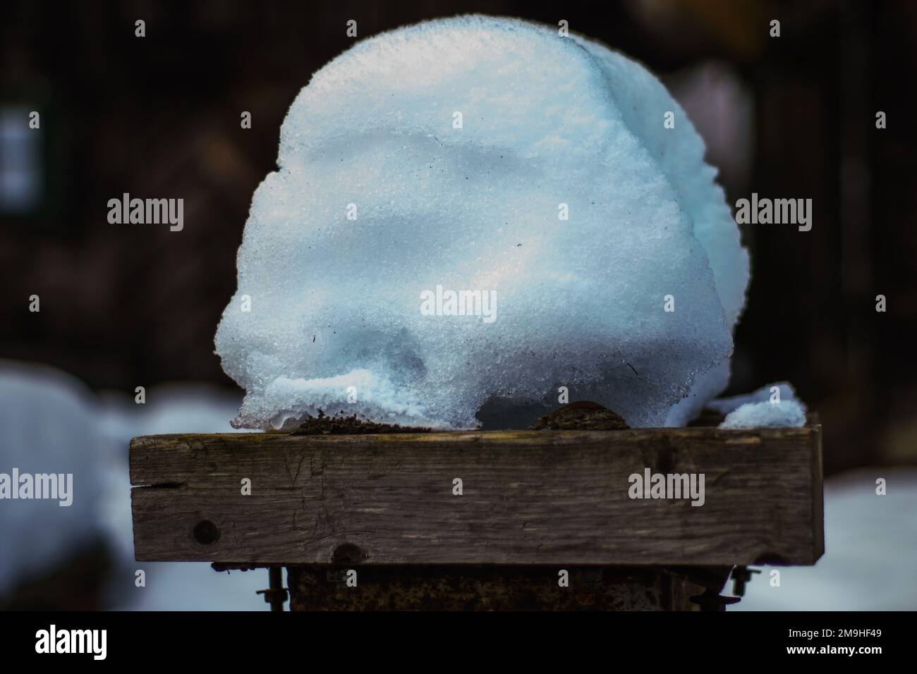 A selective focus of a pile of snow on the wooden object, blurred ...