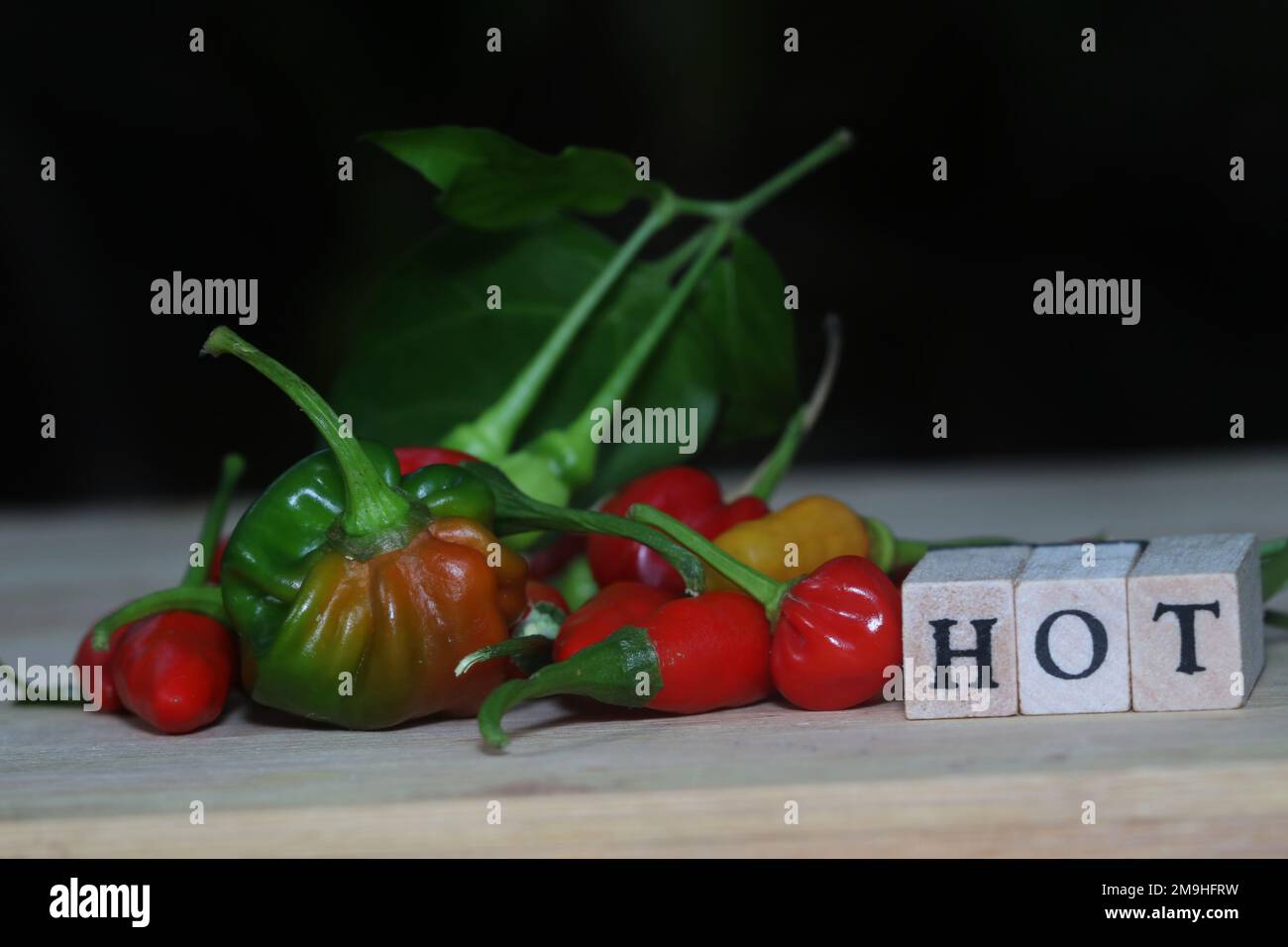 A closeup of chillies with the word ''hot" made with wooden cubes ...