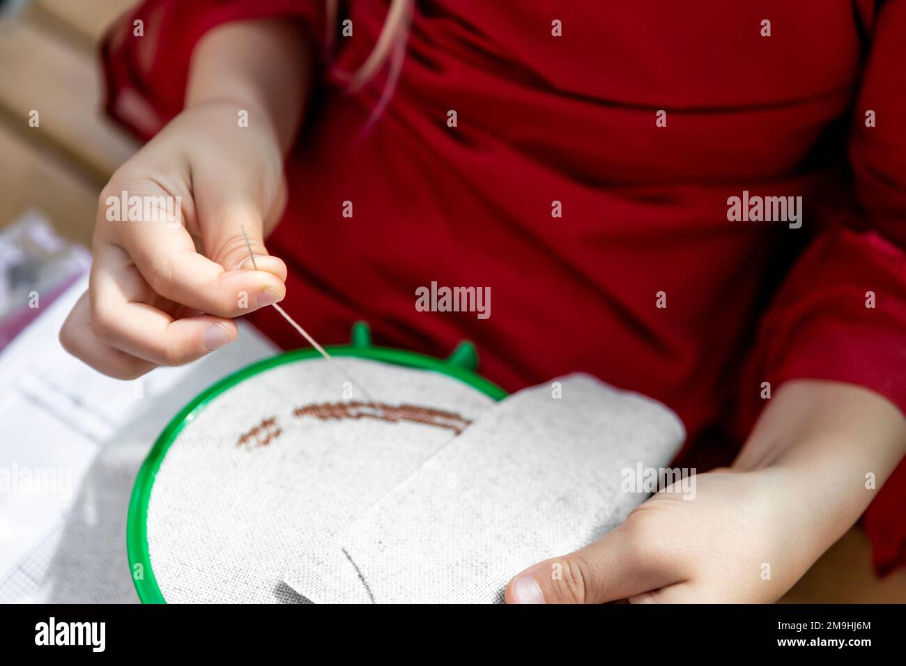 Close-up detail female child hands embroidering round hoop fabric frame ...