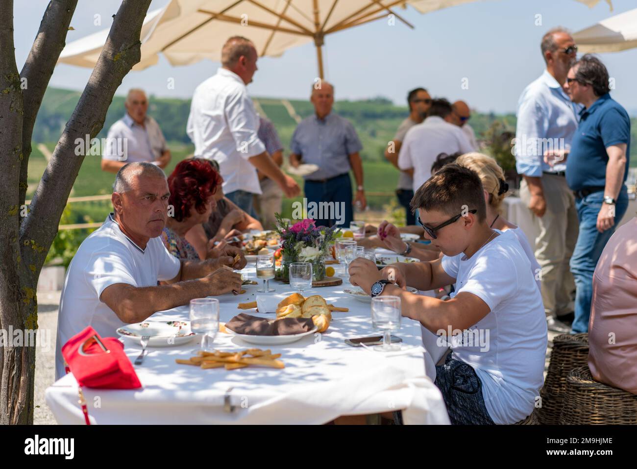 people eating authentic italian food among the vineyards of Coazzolo in ...