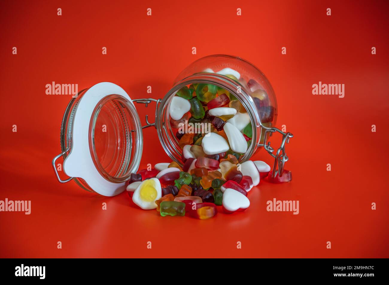 candy sweet jar opened with candy on red table background isolated ...