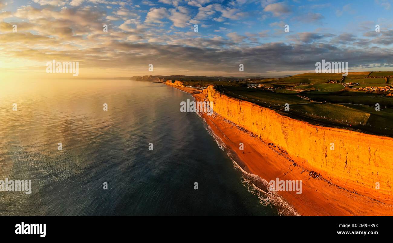 Coastal cliffs above beach at sunset, Dorset, England, UK Stock Photo ...