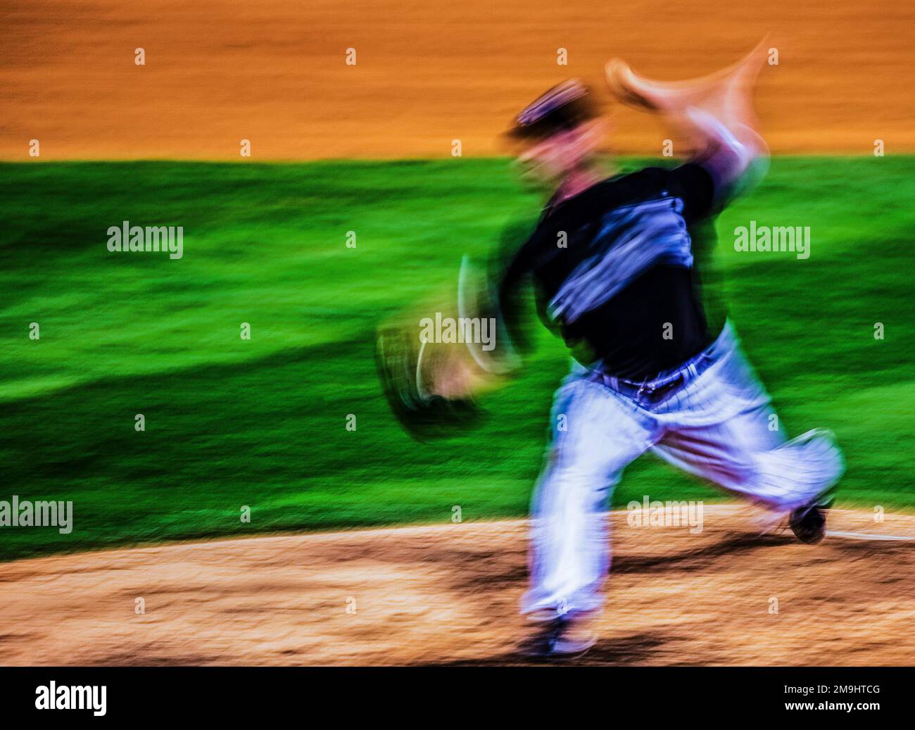 Baseball pitcher in motion, catching ball Stock Photo - Alamy