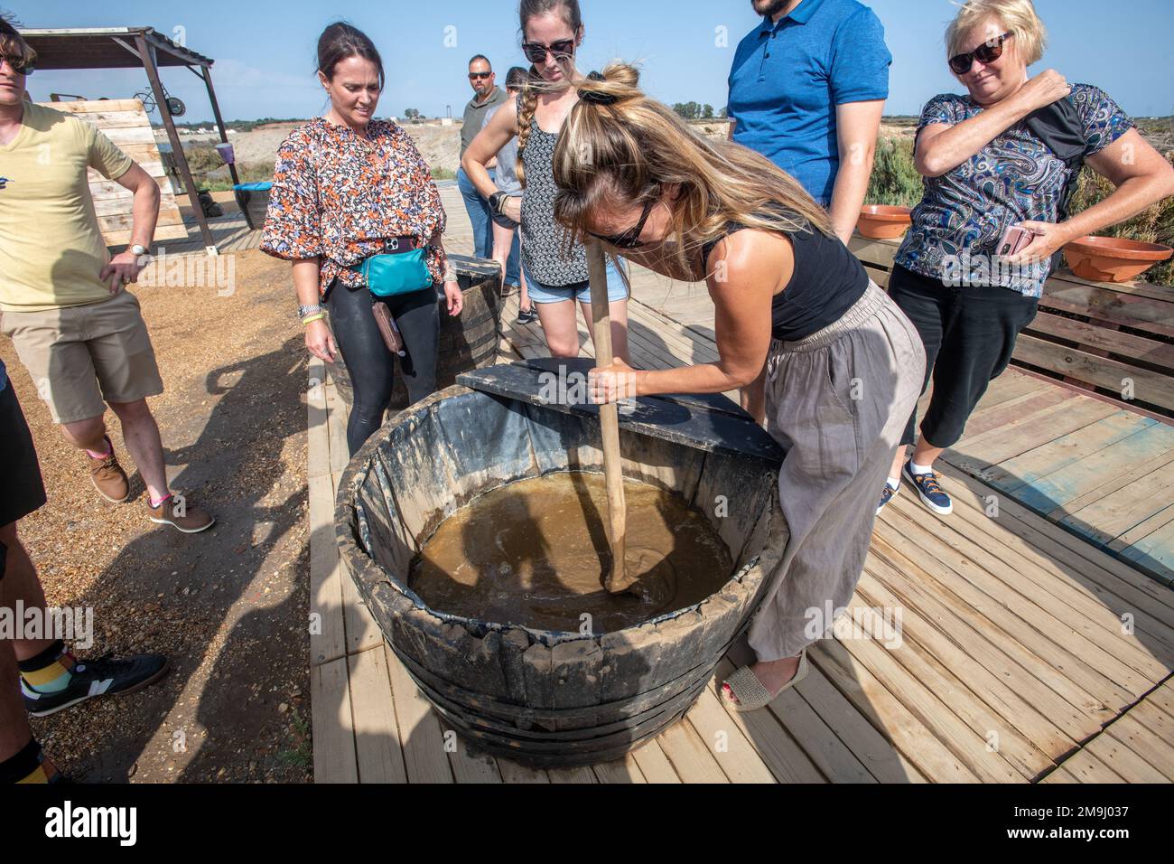 Woman stirs healing mud at salt marshes, Isla Cristina, Spain Stock ...