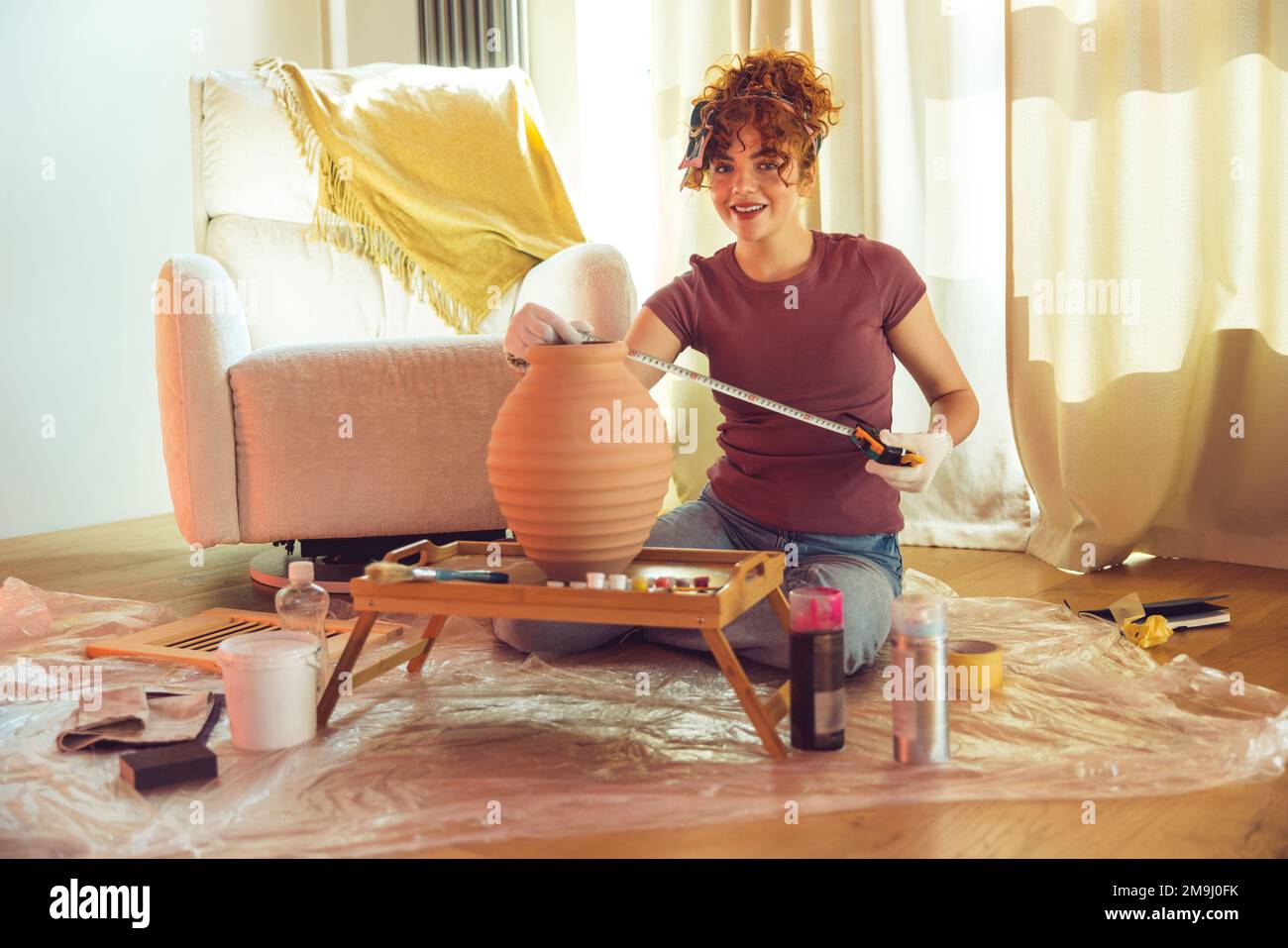 Female artist painting the clay pot and looking involved Stock Photo ...