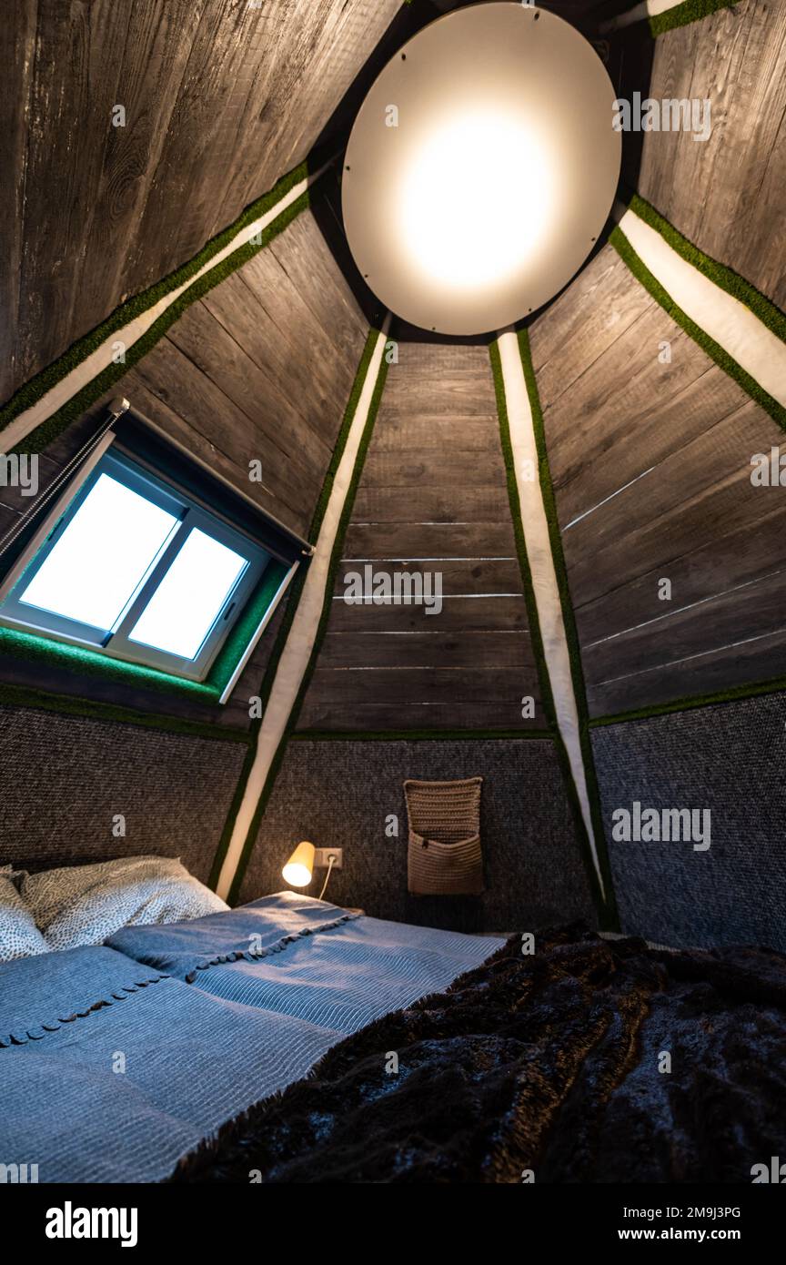 Double bed in bedroom of pyramid shape wooden cabin. Pyramid shape ...