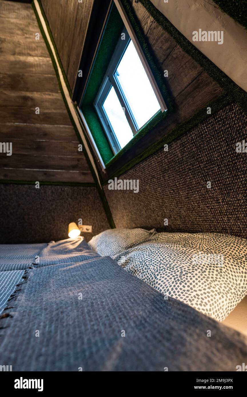 Double bed in bedroom of pyramid shape wooden cabin. Pyramid shape ...