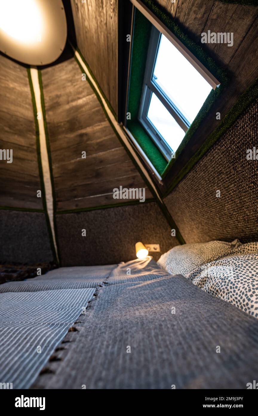Double bed in bedroom of pyramid shape wooden cabin. Pyramid shape ...